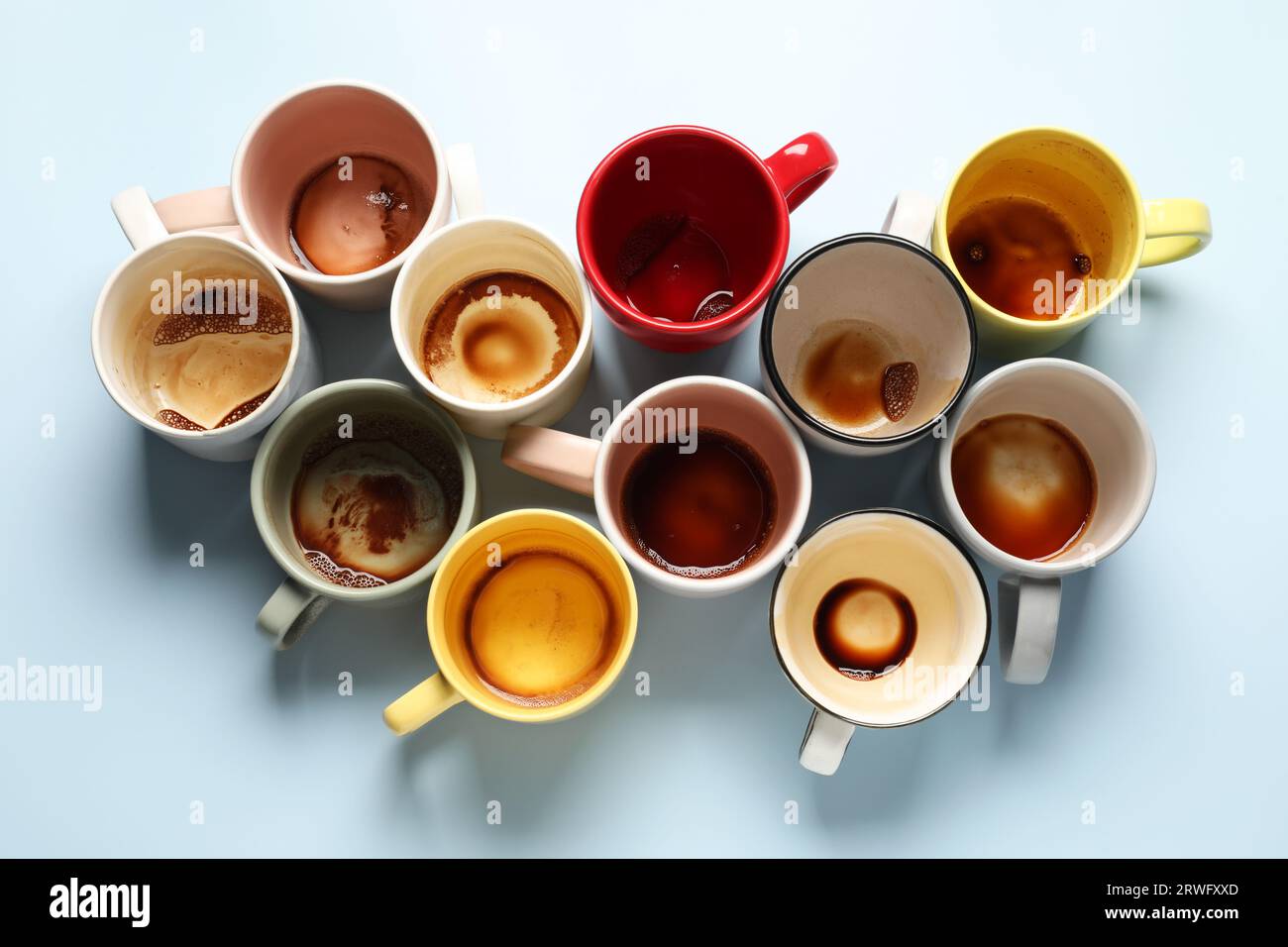 Many dirty cups after drinking coffee on light blue table, flat lay ...