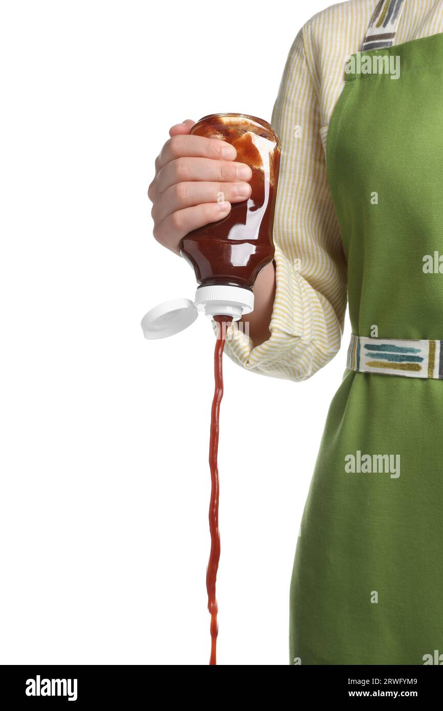 Woman pouring tasty ketchup from bottle on white background, closeup ...