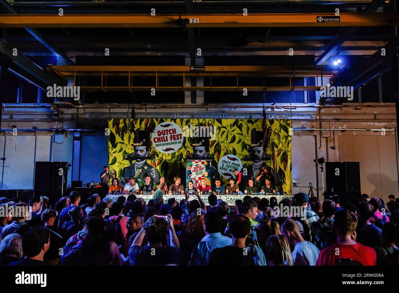 People are seen watching the participants eating spicy peppers. The ...
