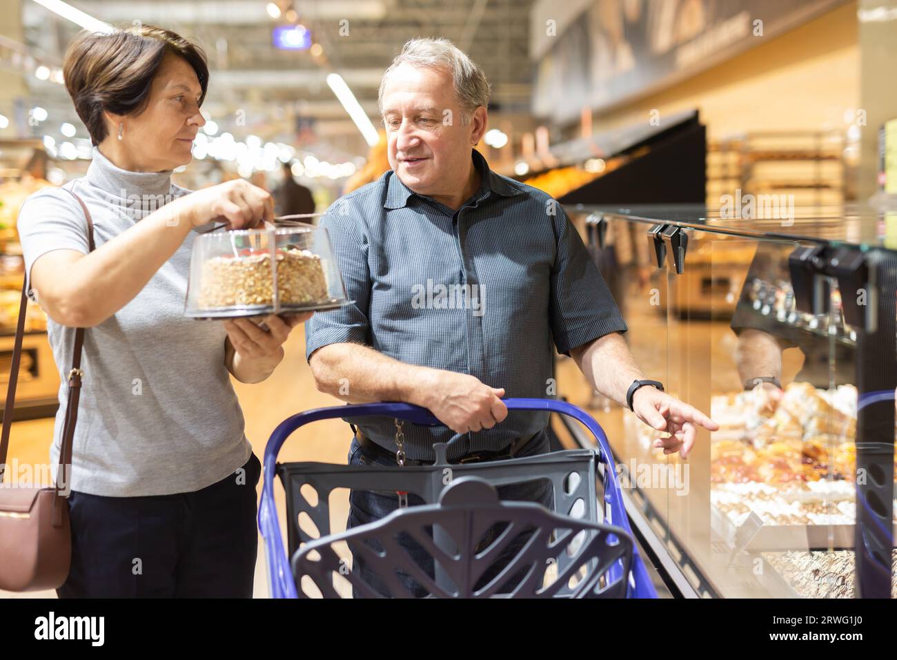 Husband and wife choose cake in store for festive dinner Stock Photo ...
