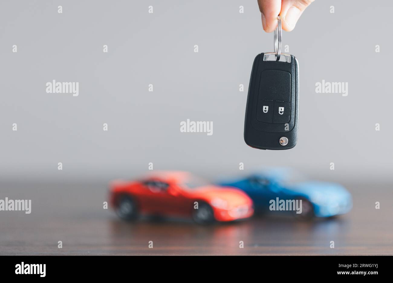 Hand holding car keys and a remote control for keyless entry. Car loan ...
