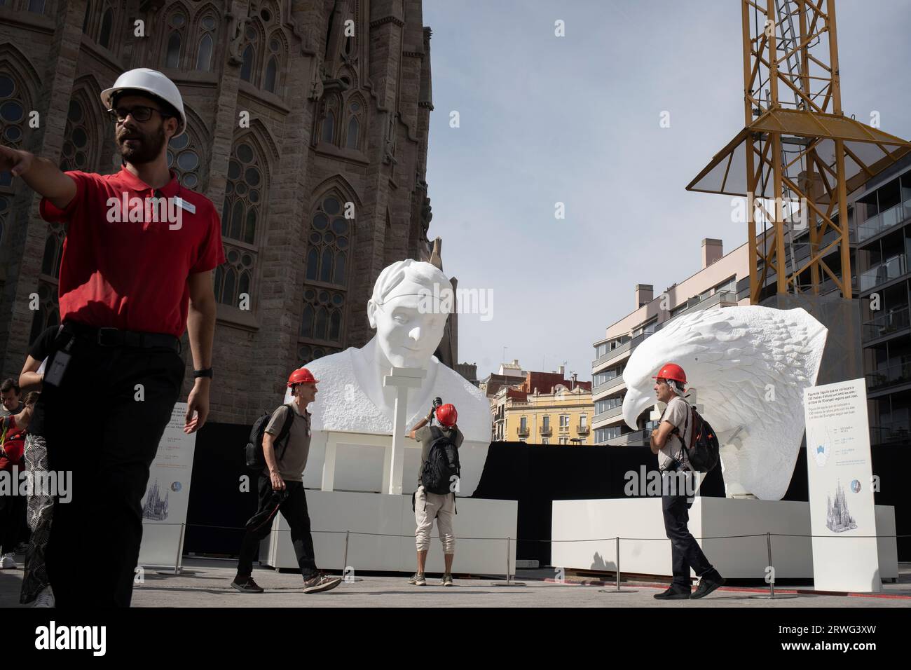 Workers of the Sagrada Familia next to the figures of the evangelist ...