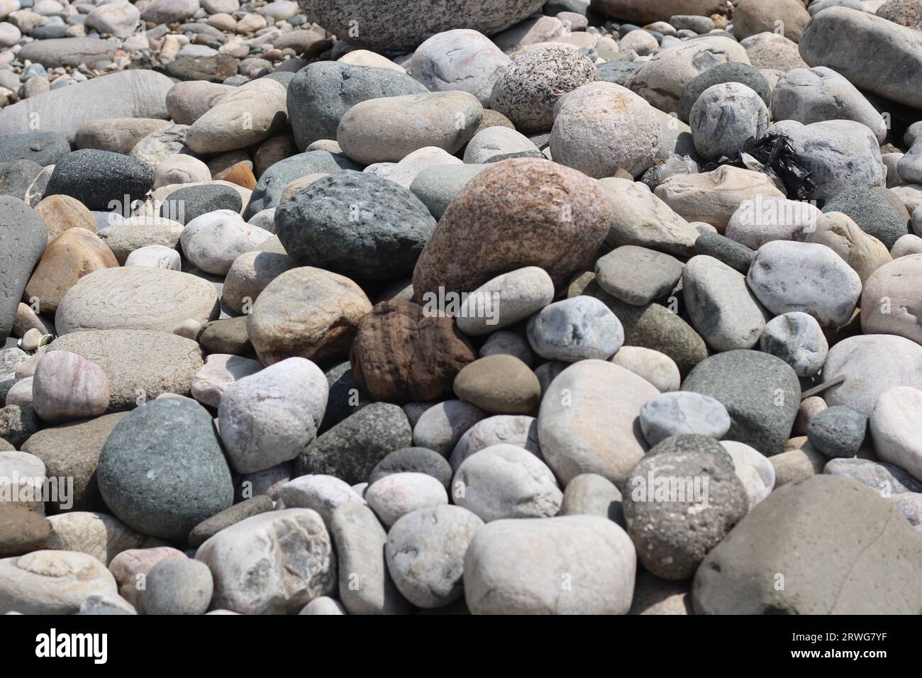 Different color and sizes stone in the river side Stock Photo - Alamy