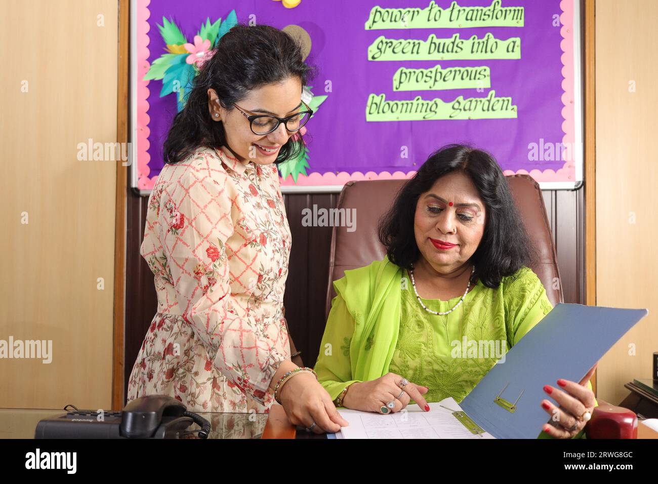 School Principal mam checking some important documents in a file with ...