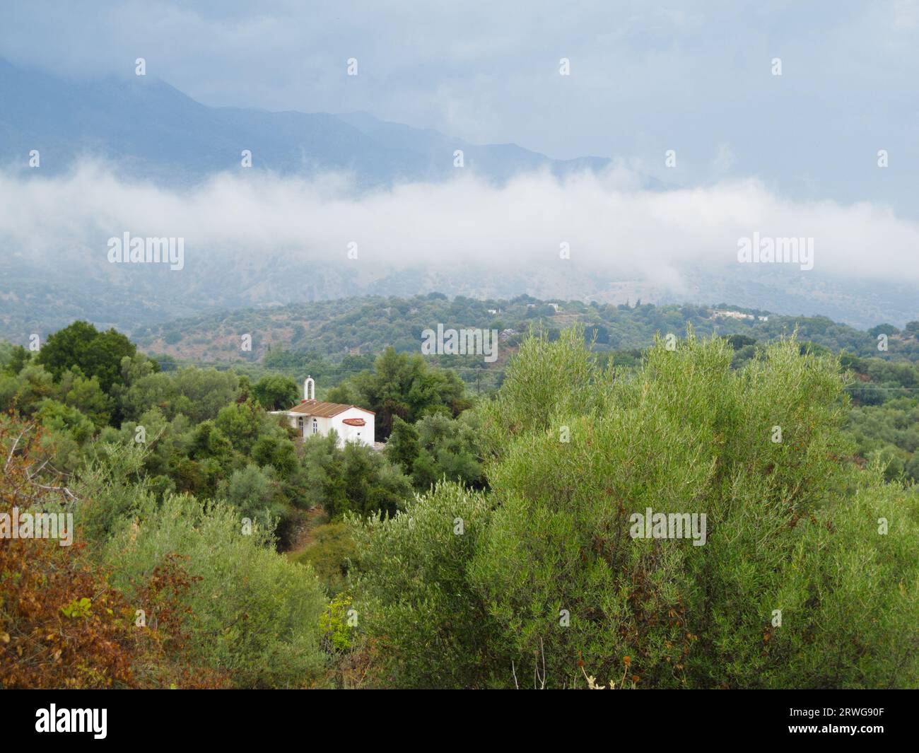 White painted chapel church in low clouds viewed from roads through ...
