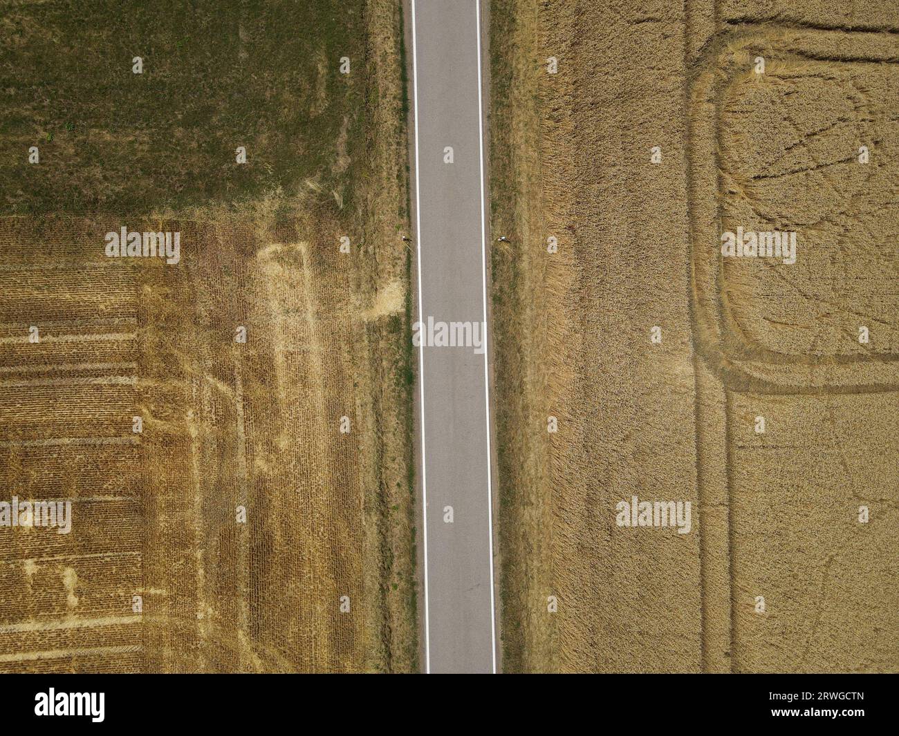 Aerial view of a road between crop and grass fields in the landscape ...