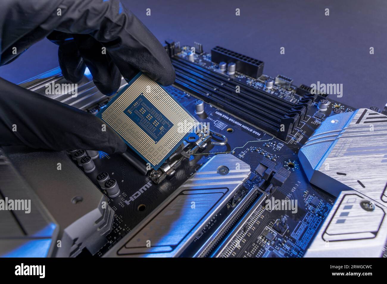 The engineer's gloved hand holds the CPU chip against the background of ...