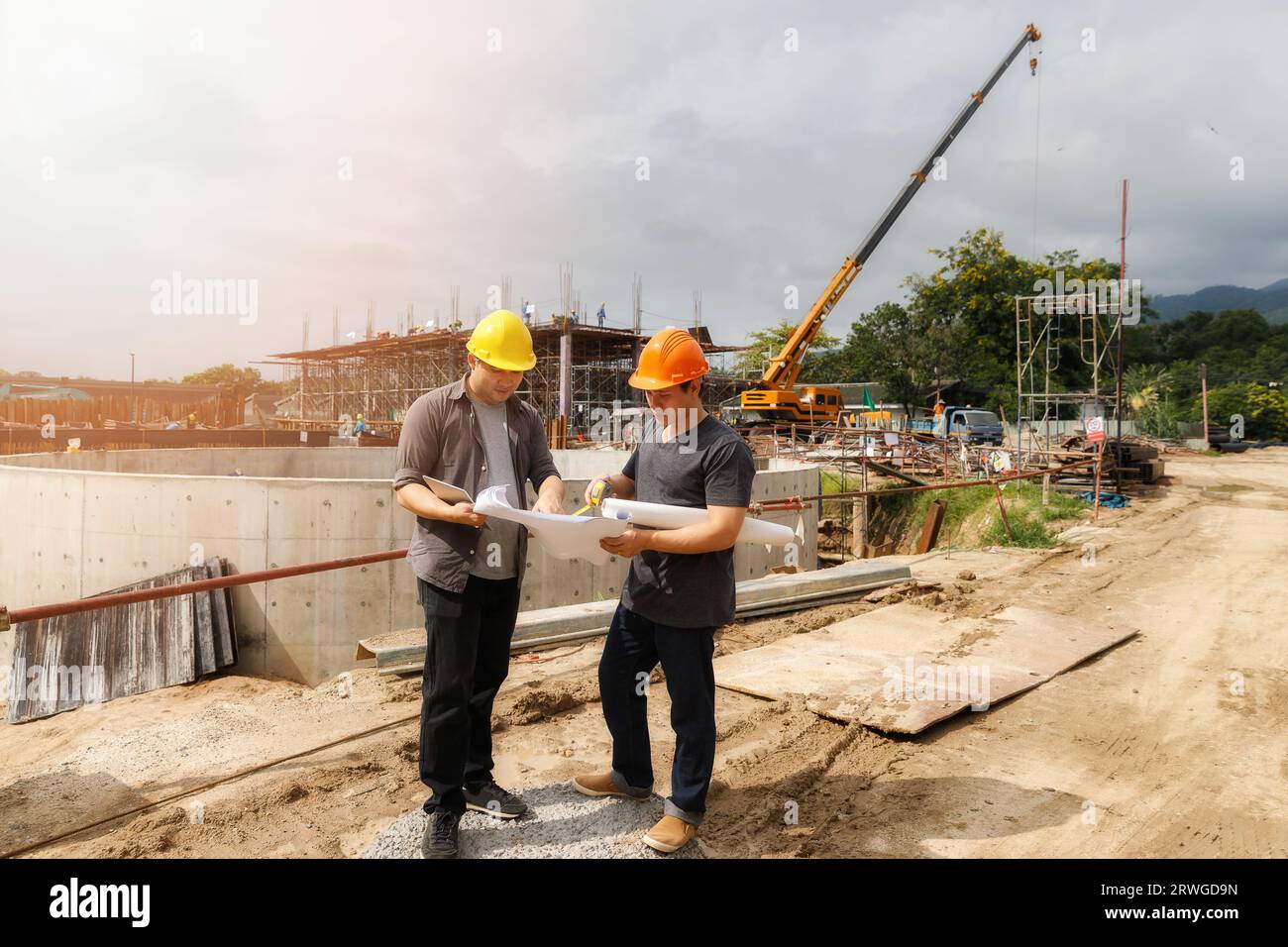 Team of construction workers discussing project details with blueprint ...