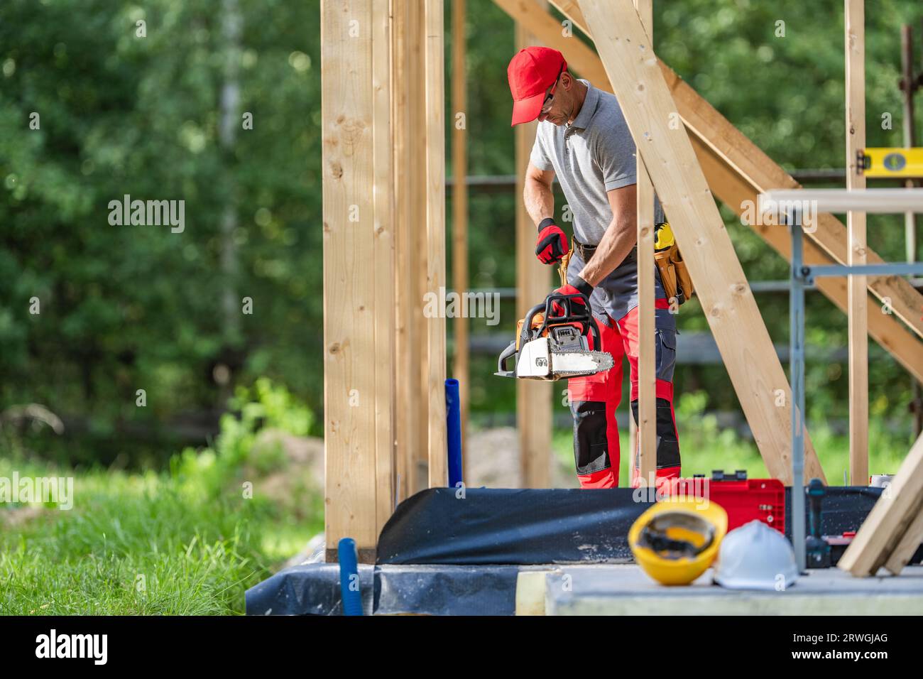 Caucasian Construction Site Worker with a Chainsaw Inside Wooden ...