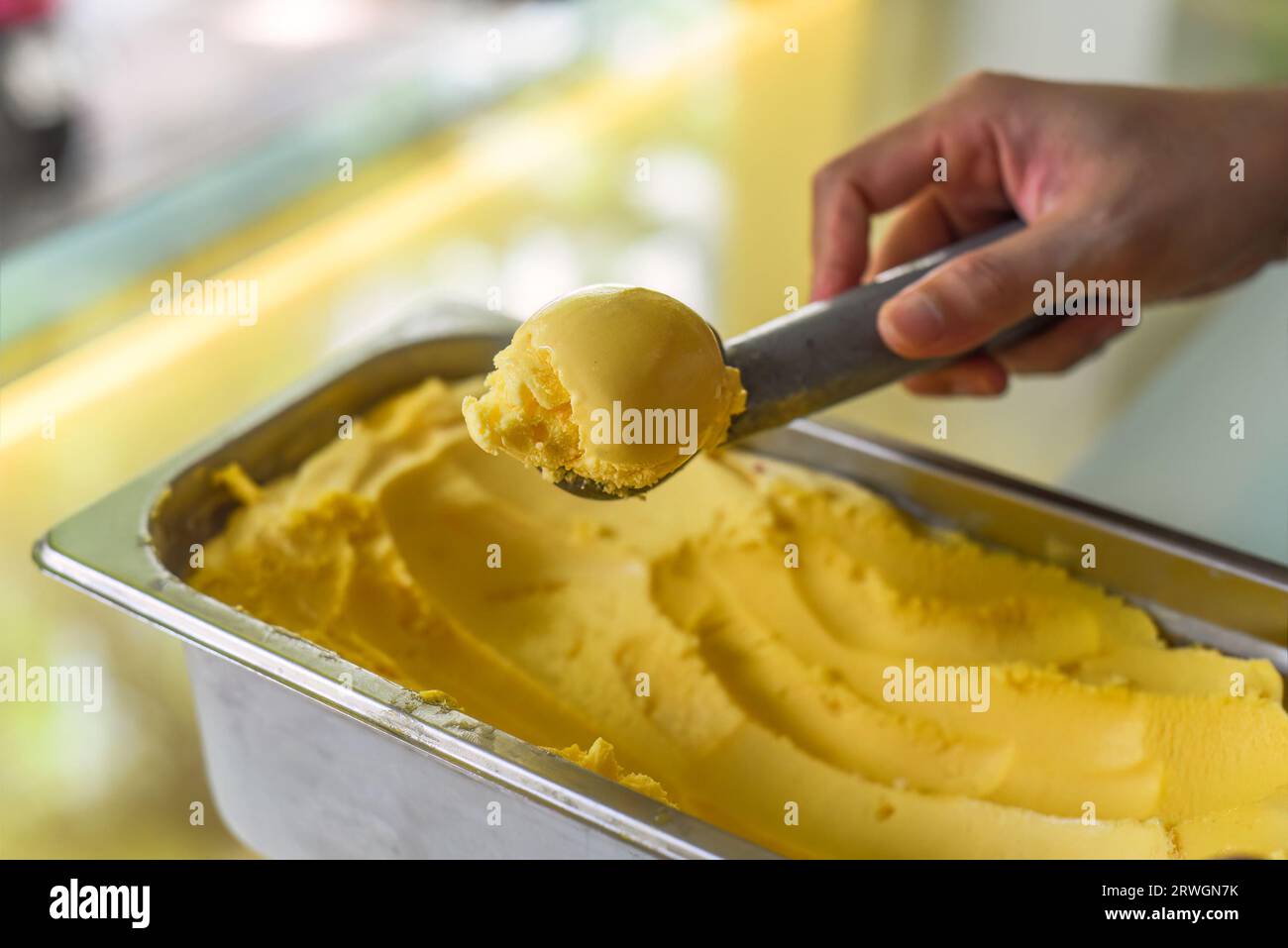 hand scooping a scoop of Passion fruit ice cream into a spoon in fridge Stock Photo - Alamy
