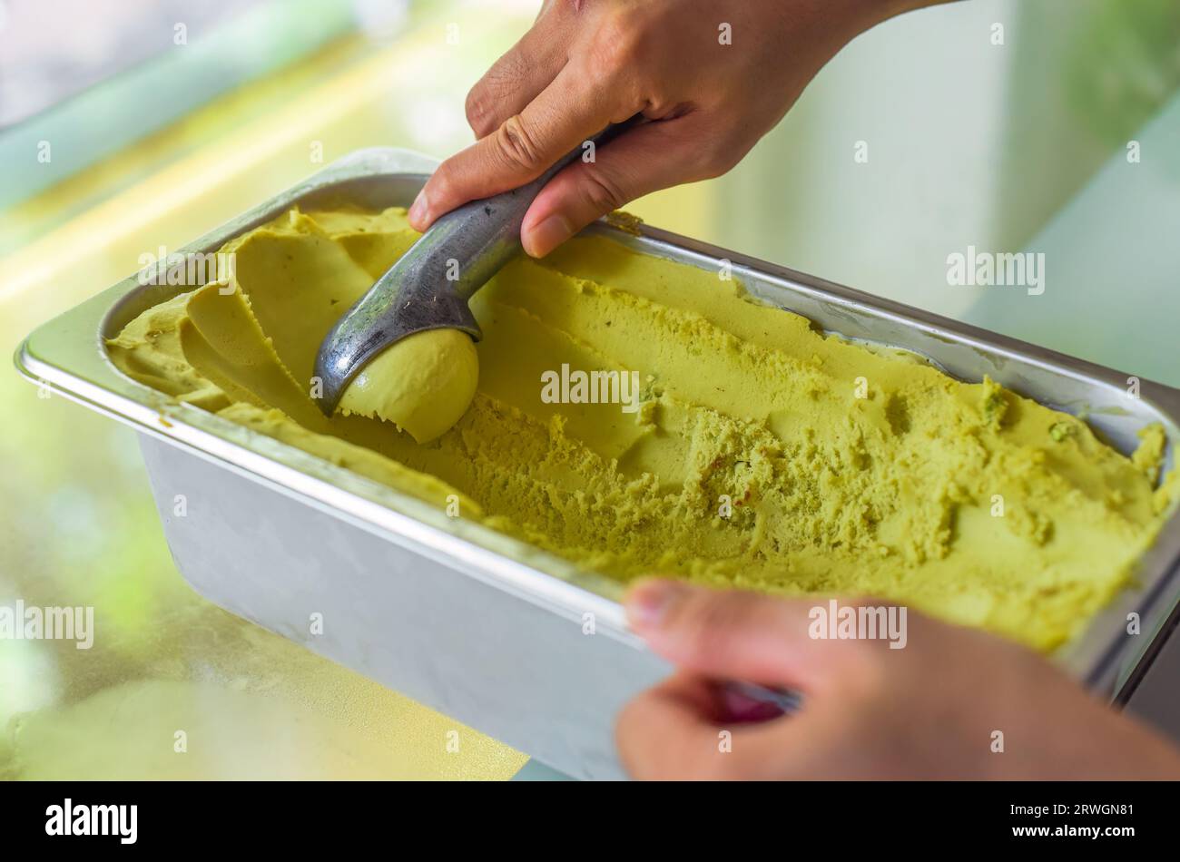 hand scooping a scoop of Avocado ice cream into a spoon in fridge Stock ...