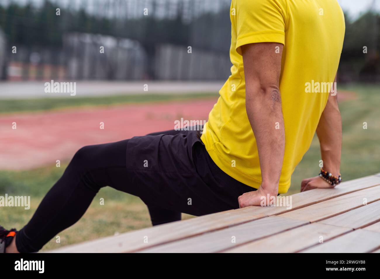 Strong man in comfortable clothes doing backward push-ups leaning on ...