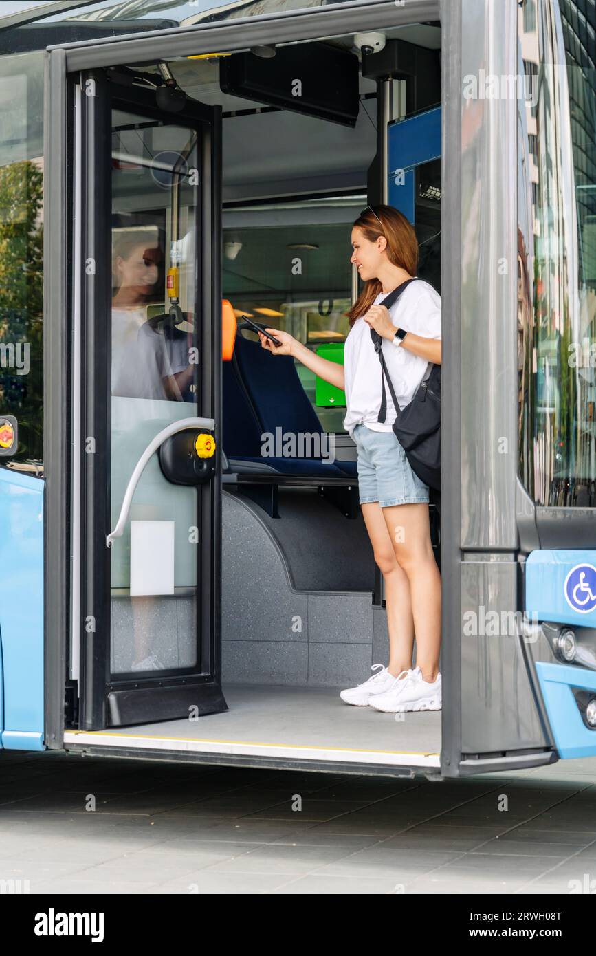Woman passenger of public transportation in city pays for bus using her ...