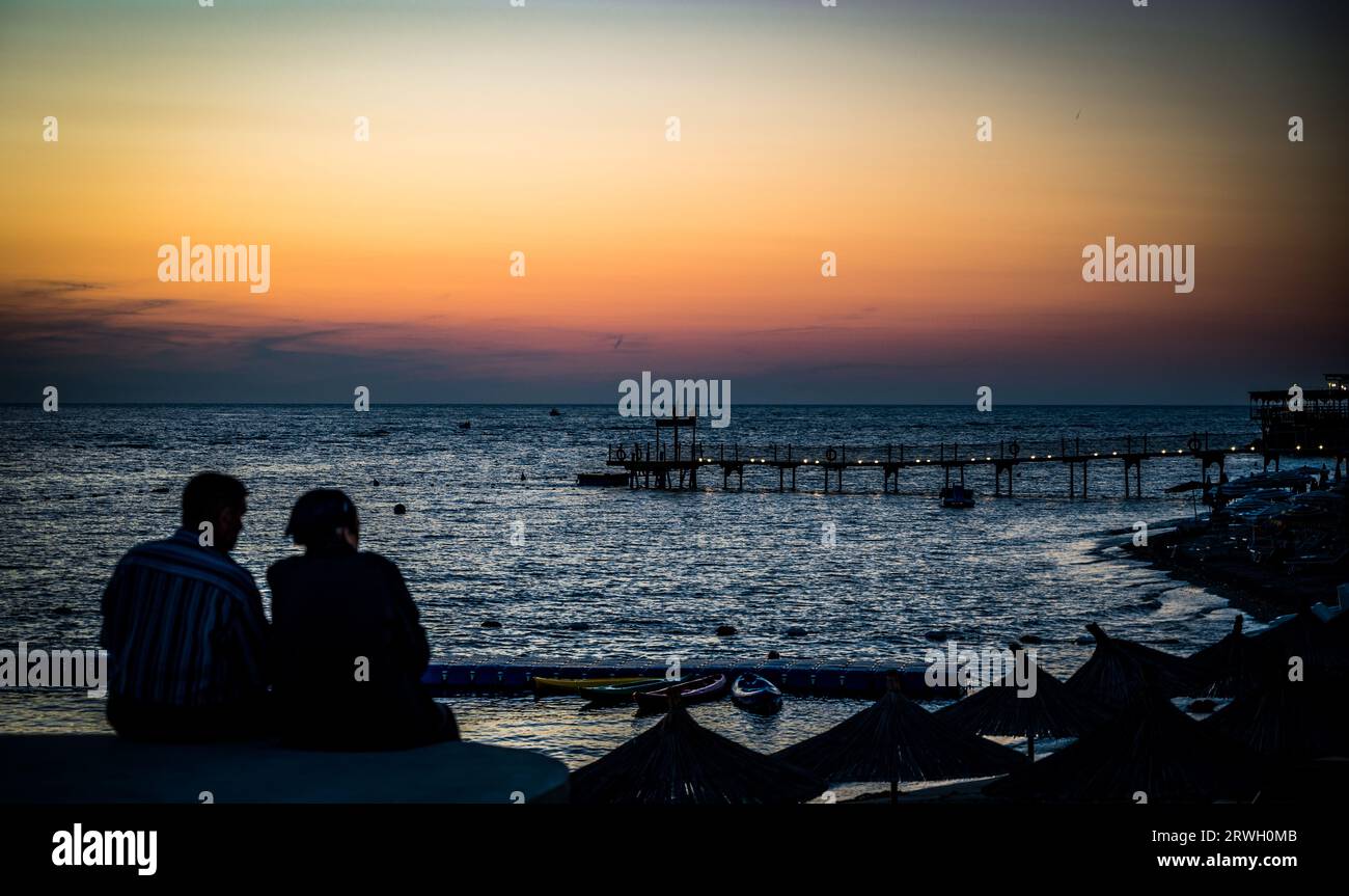 Couple watching sunset together enjoying view sunset sea on vacation ...