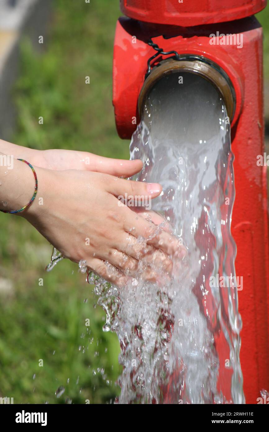 red road hydrant and the refreshing water that comes out copious and ...