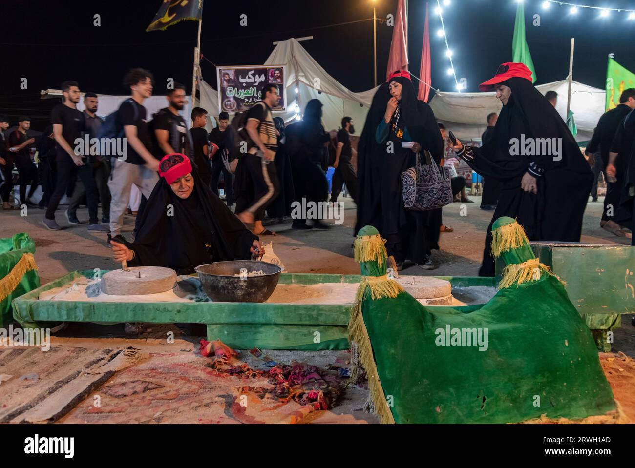 A Shia woman rotates stone grinder symbolizing it with "Hazrat Fatima ...