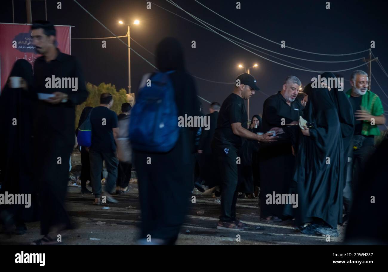 Iraqi Shia Muslims distribute food among Shia Muslim pilgrims marching ...