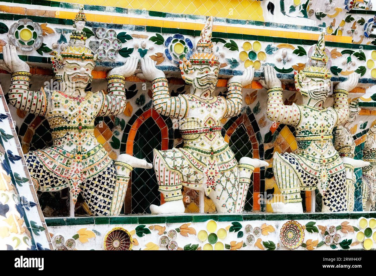 Three ornate statues on a temple wall. The statues are of three figures ...