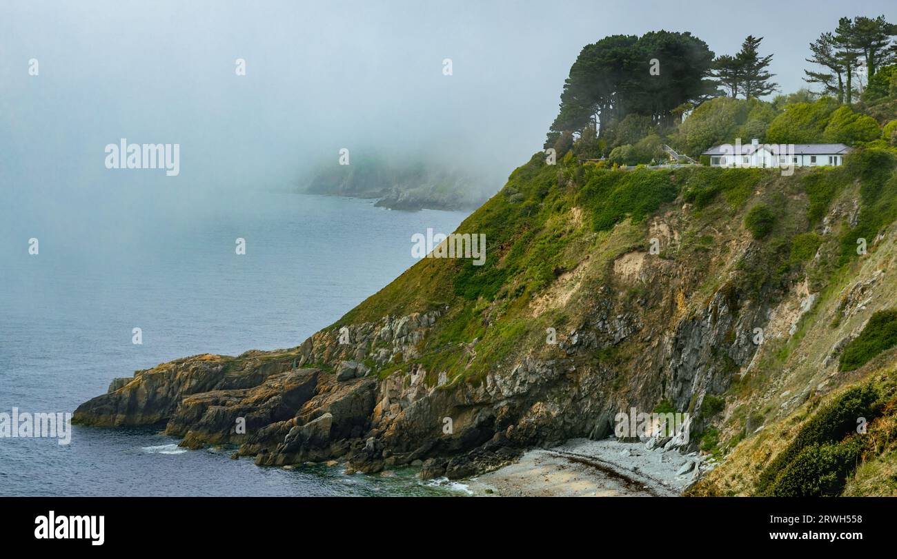 The Peninsula of Howth Head on a foggy day, the cliffs warped by fog ...