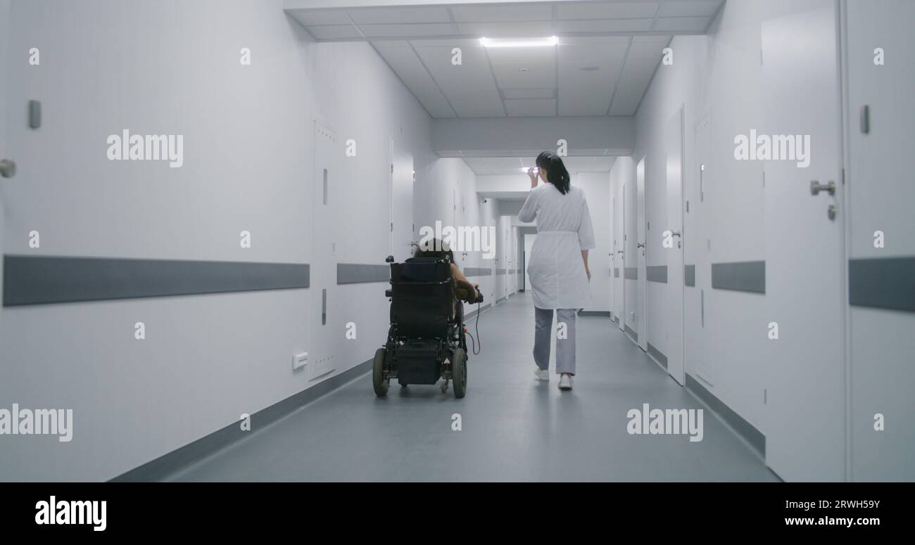 Woman in motorized wheelchair leaves elevator with doctor, rides along ...