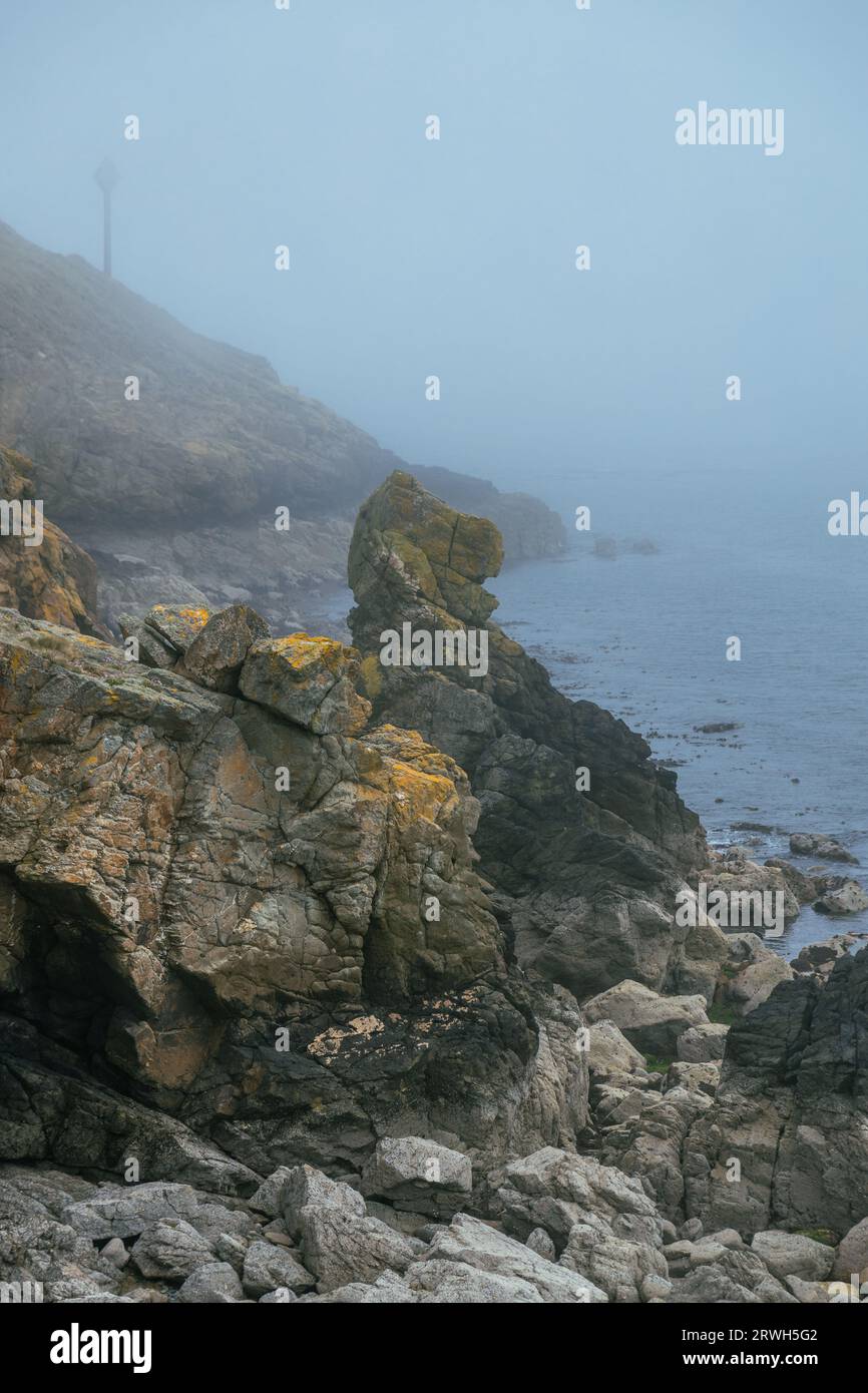 The Peninsula of Howth Head on a foggy day, the cliffs warped by fog ...