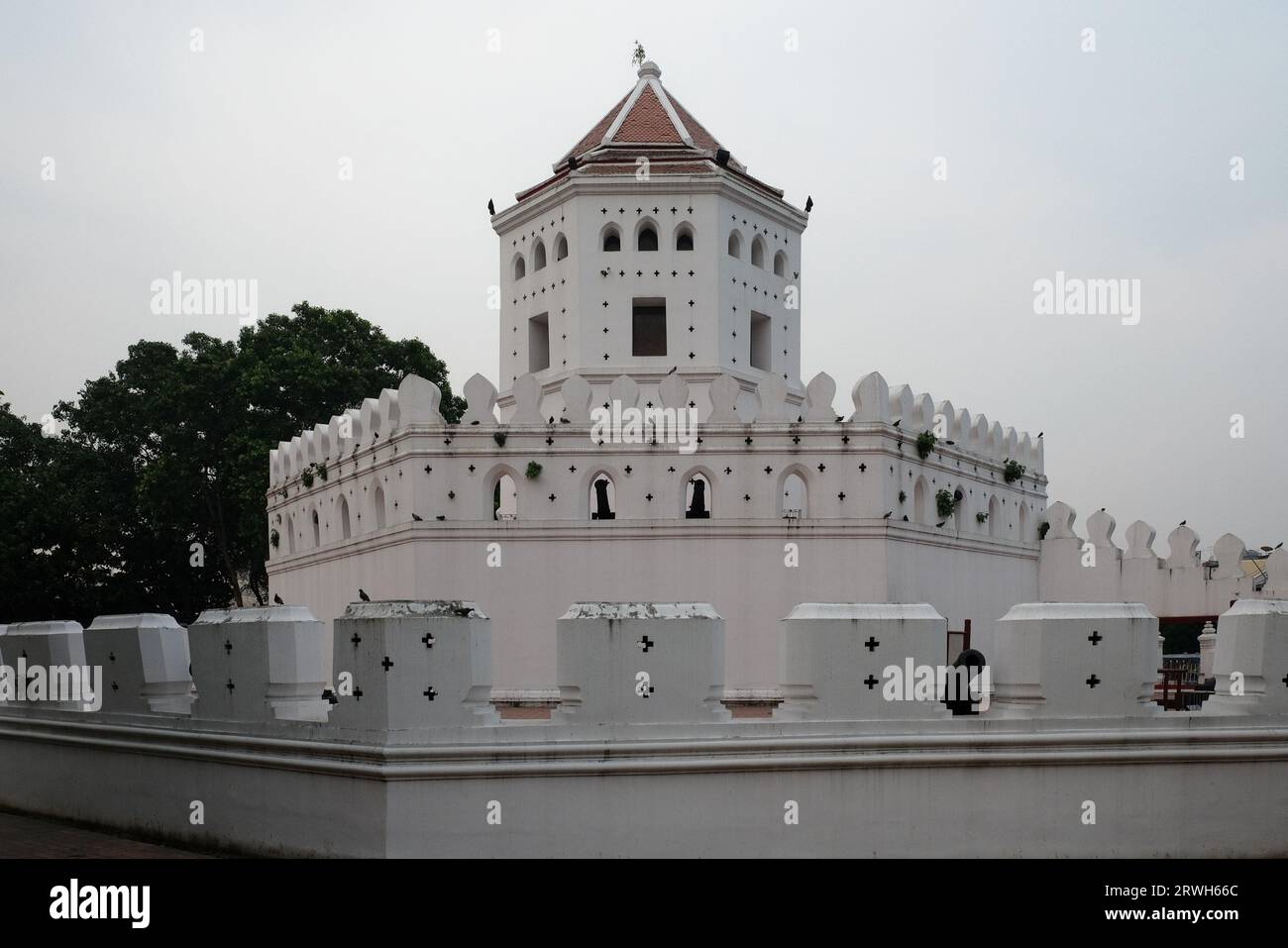 A white fort-like structure with a red roof, surrounded by a wall with ...