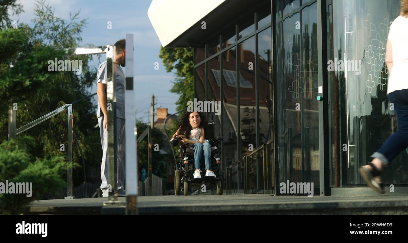 Woman with physical disability rides into clinic entrance on motorized ...