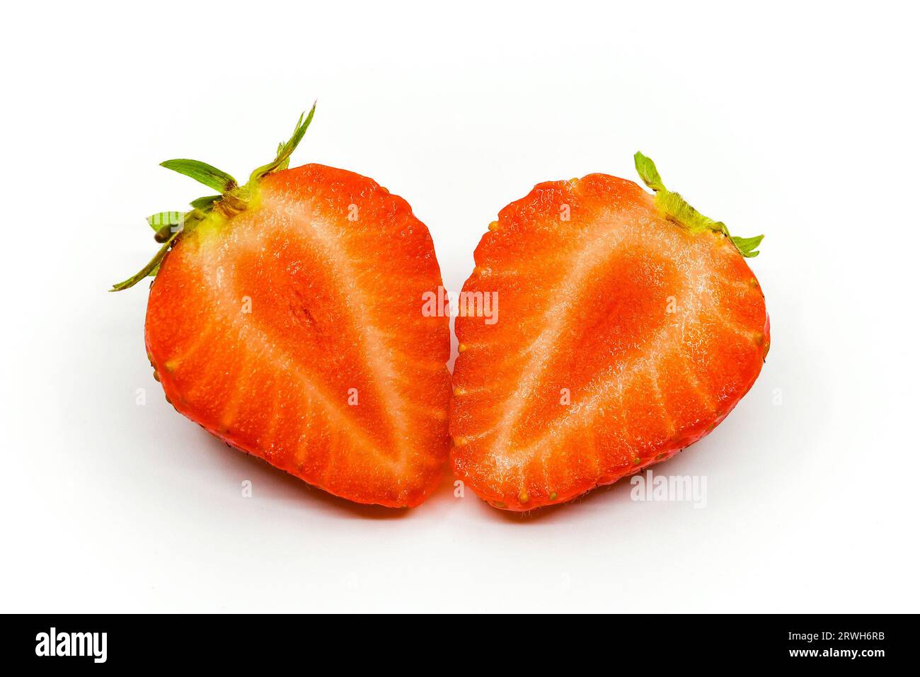 Fresh ripe strawberry cut in half on a plain white background Stock ...