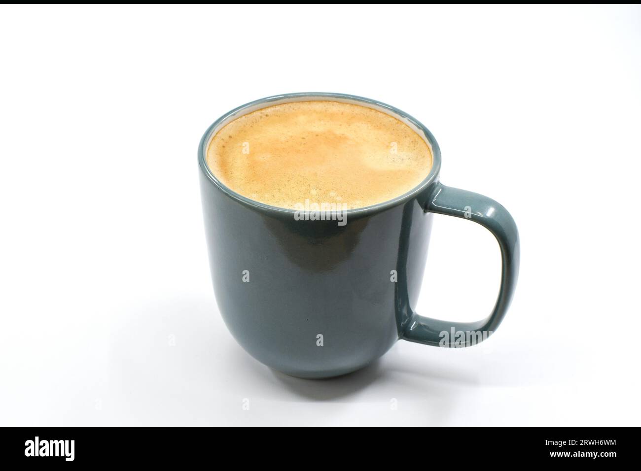 Mug of hot frothy coffee isolated on a plain white background. Copy ...