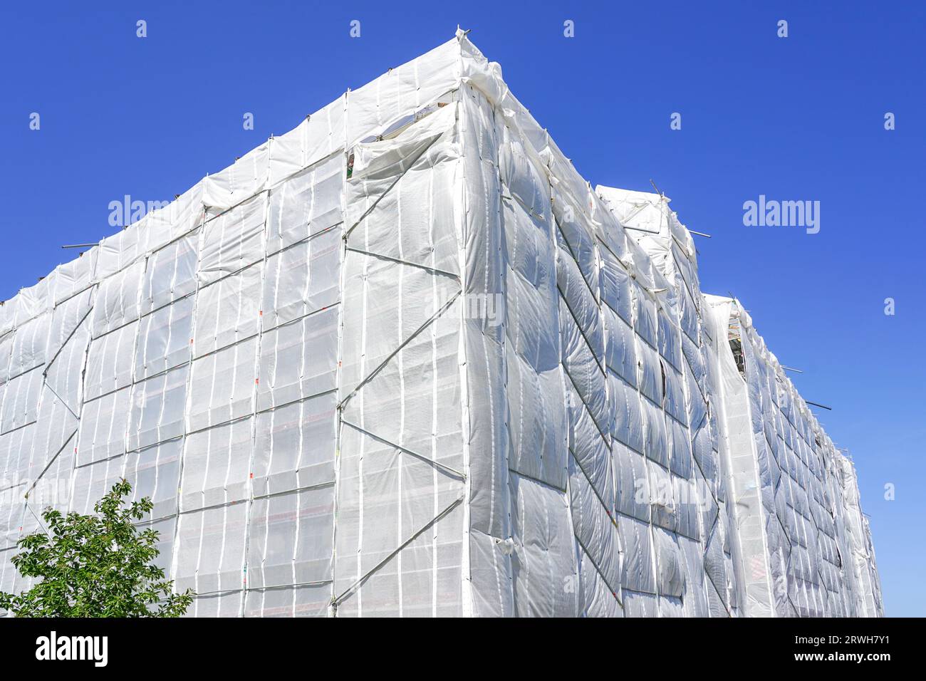 With white safety net covered multistorey residential building facade ...