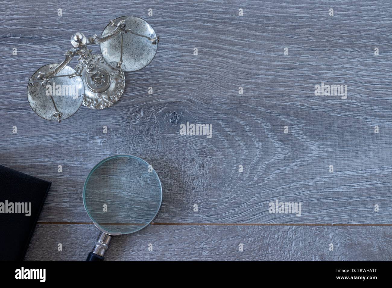 Ancient balance scale with magnifying glass and notebook on wooden ...