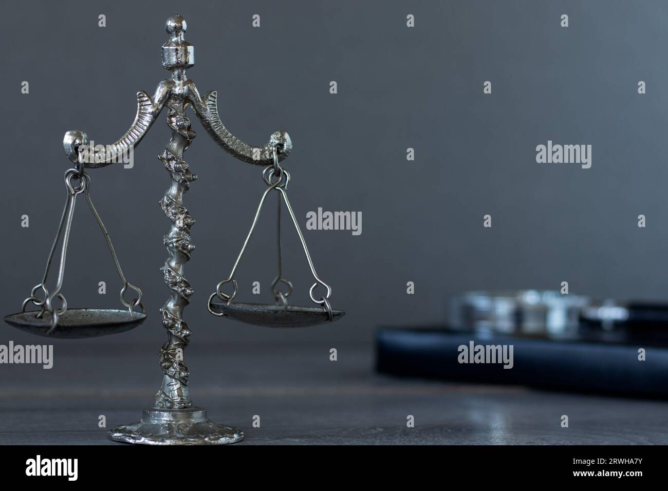 Ancient balance scales, blank notebook, and pen on dark background ...