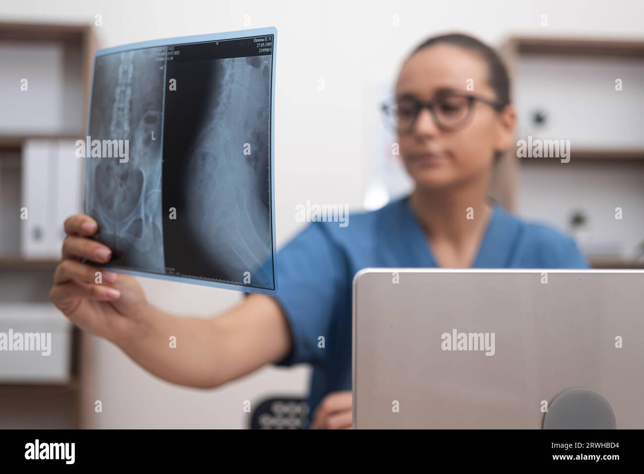 female doctor carefully examines a patient's X-ray in medical clinic ...