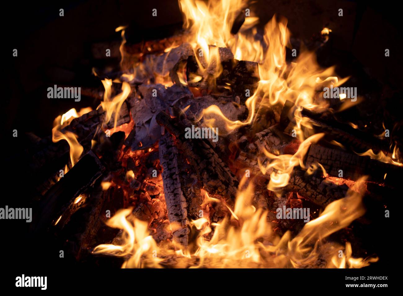 Big bonfire at night. Firewood burns in open air. Yellow flame. High ...