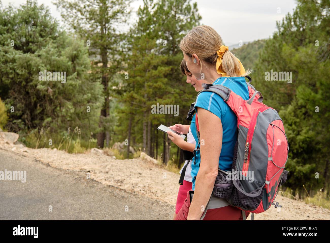 Anonymous woman following teenage boy with smartphone Stock Photo - Alamy