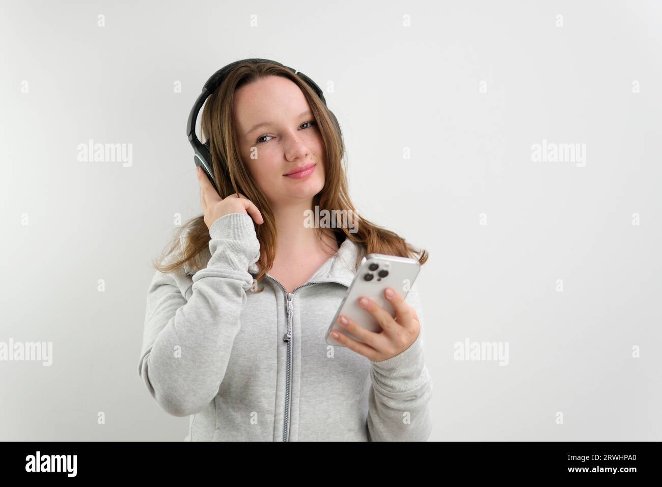 teenage girl listens to music in large professional headphones on a ...