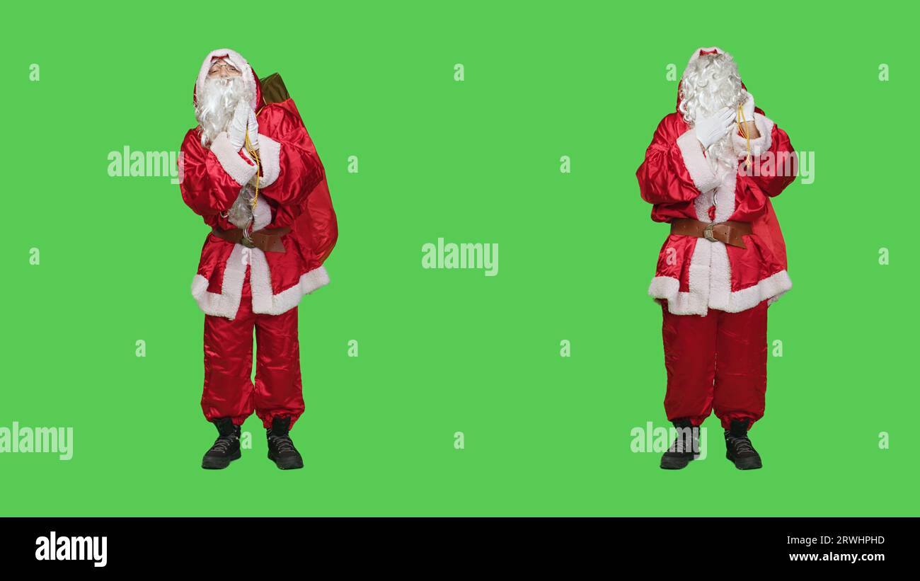 Santa claus character praying to god in studio, wearing famous red ...