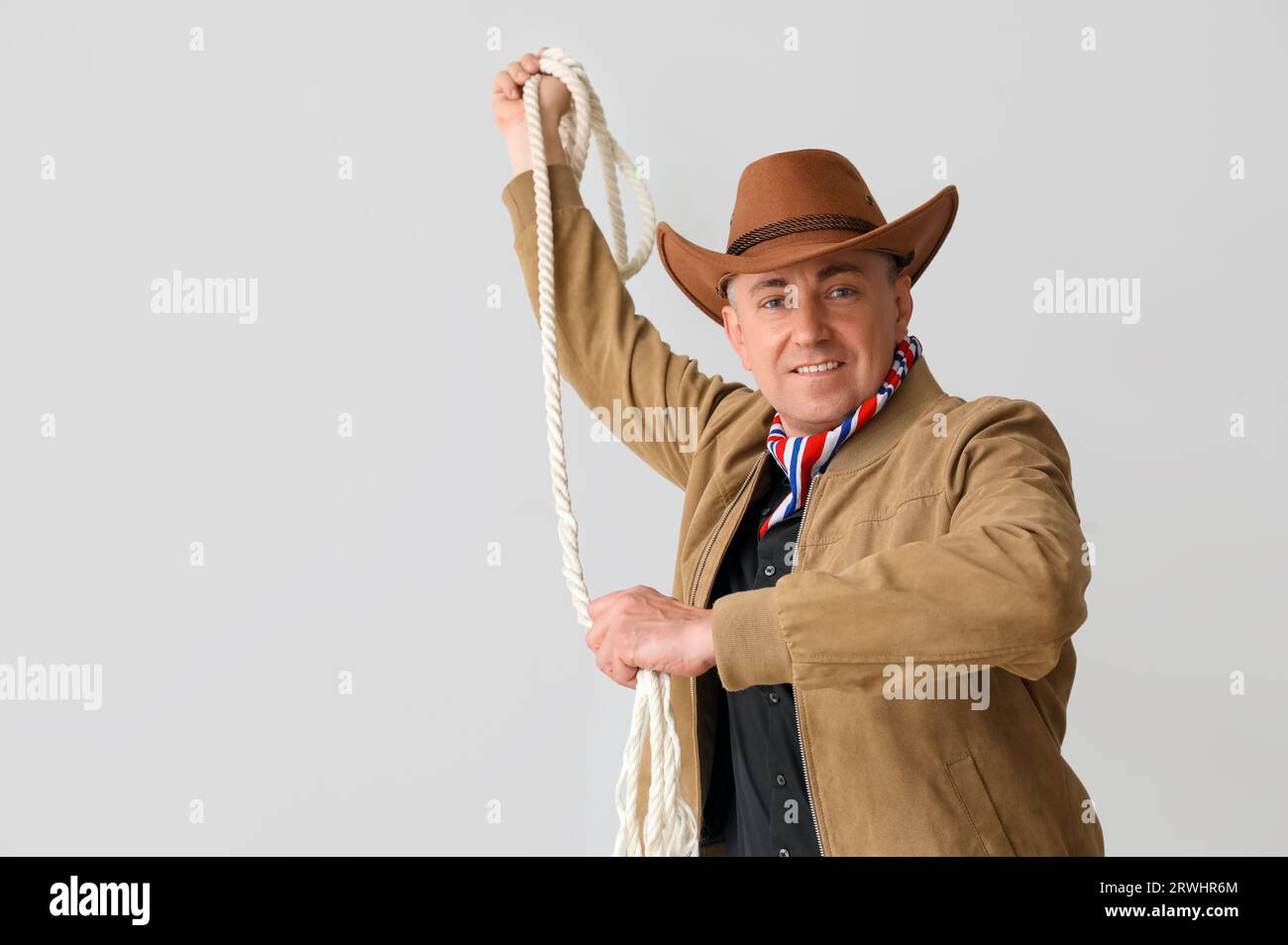 Mature cowboy on light background Stock Photo - Alamy