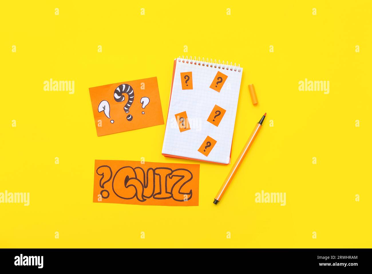 Notebook with paper quiz card and question marks on yellow background ...