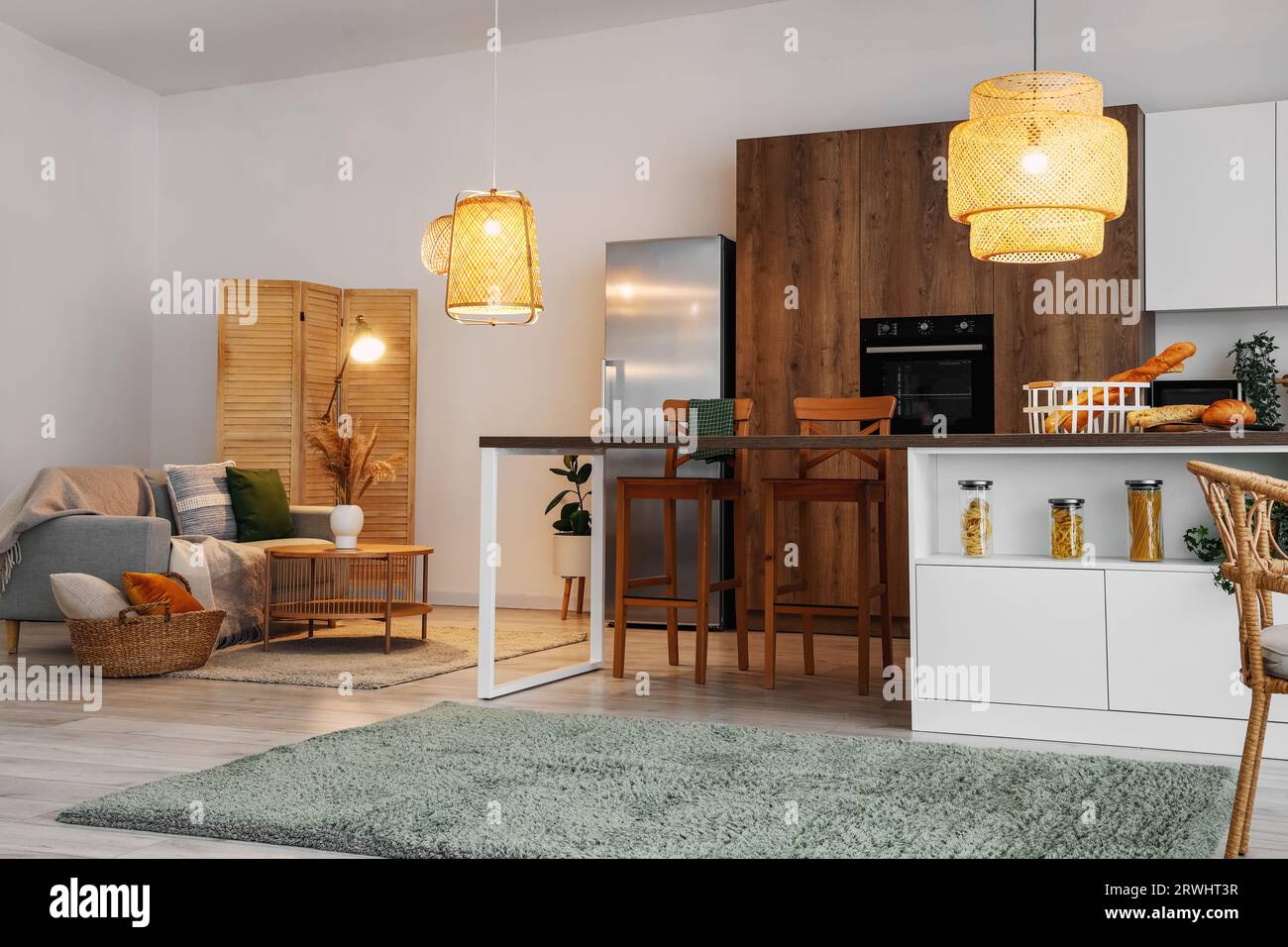 Interior of modern open space kitchen with grey sofa, island and ...