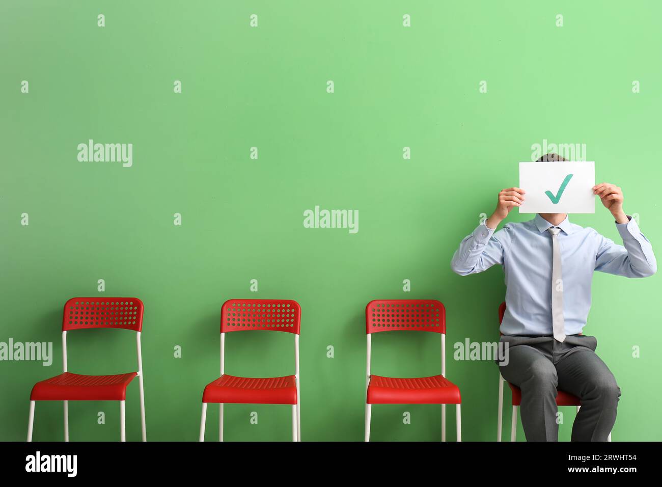 Male applicant holding paper sheet with check mark in room Stock Photo ...