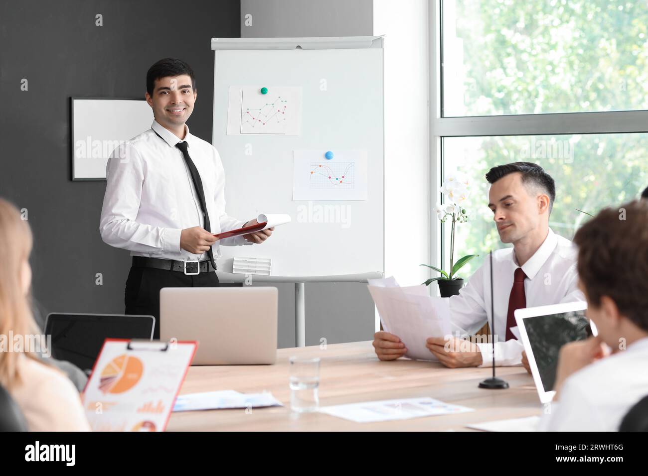 Male business consultant giving presentation to his colleagues in ...