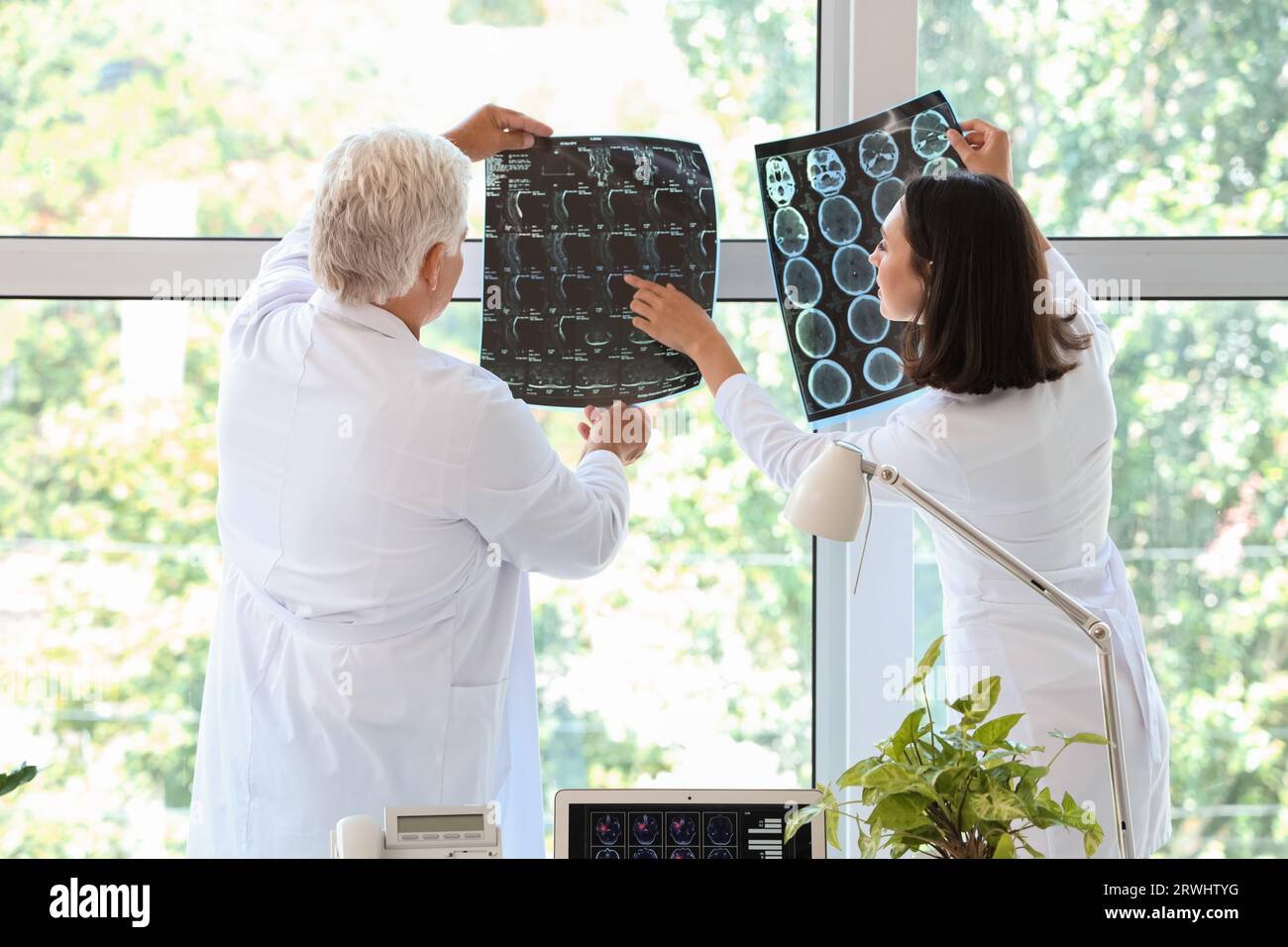 Doctors examining x-ray scan in medical office near window Stock Photo ...