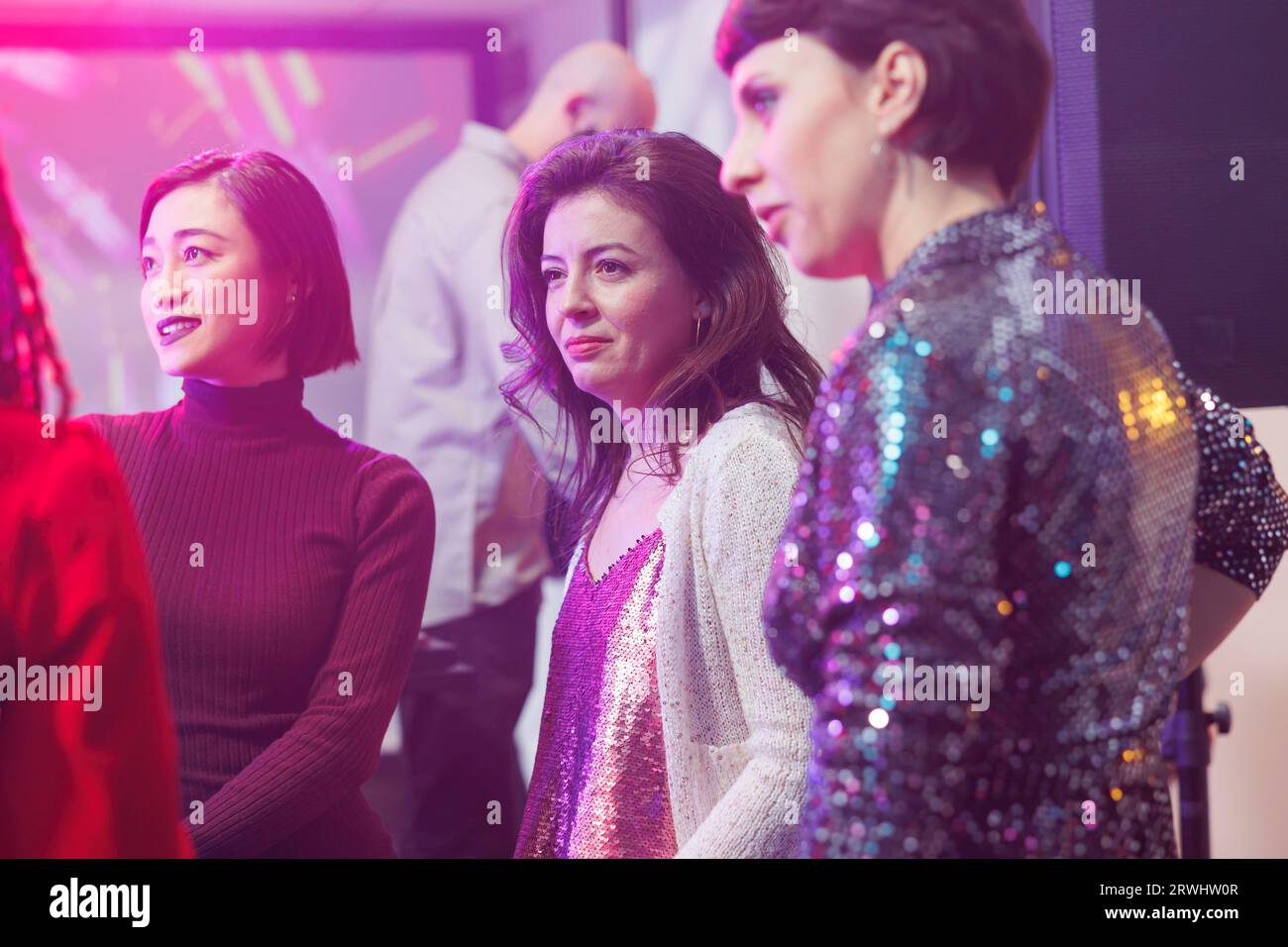 Diverse women attending party in nightclub and standing on dancefloor ...
