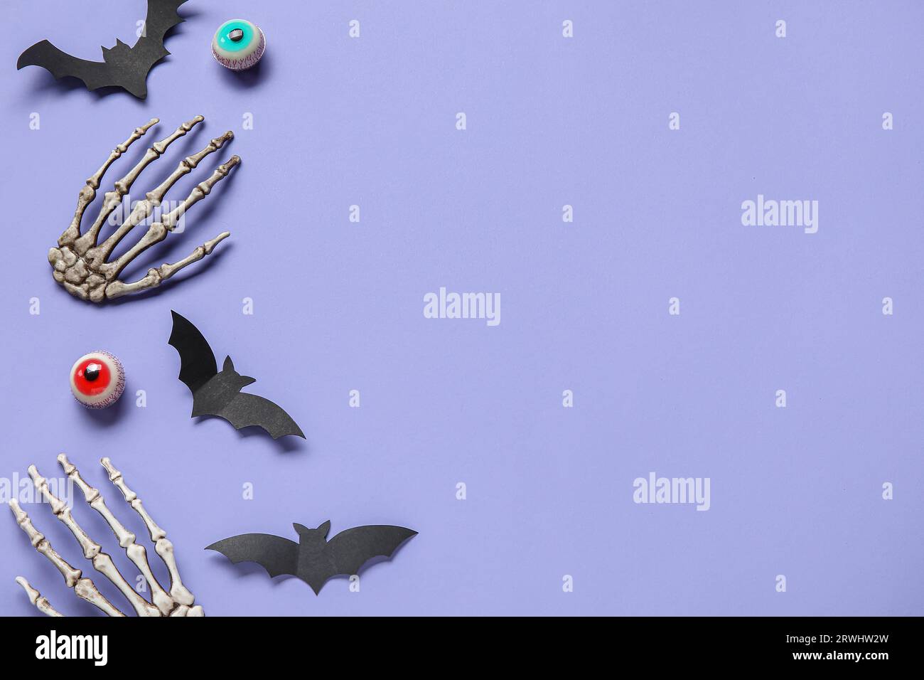 Composition with skeleton hands, tasty candies and paper bats for ...