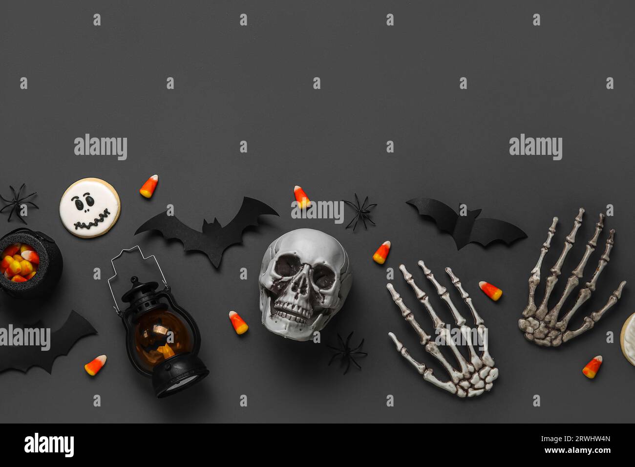 Composition with tasty candy corns, skull, skeleton hands and Halloween ...