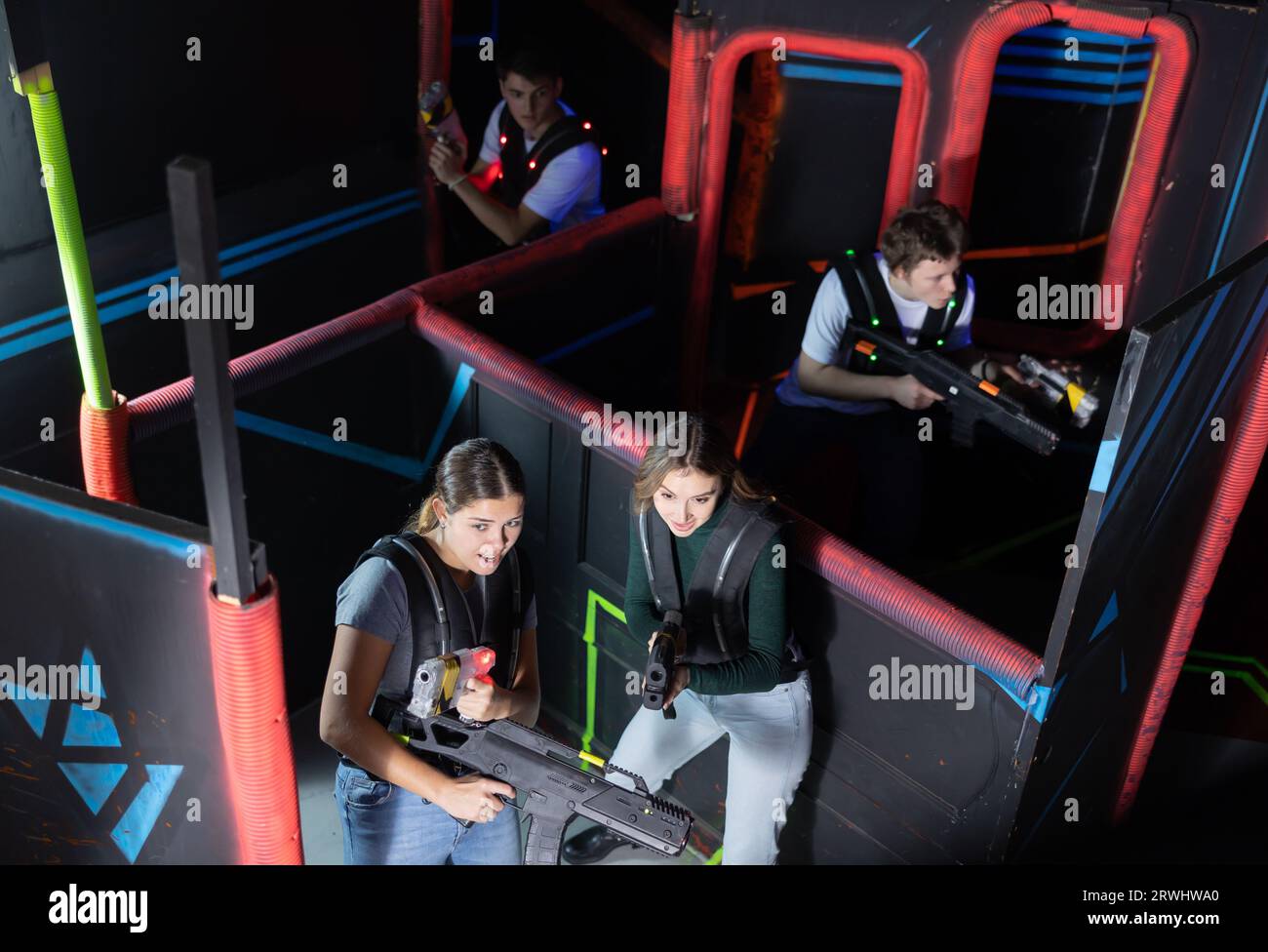 Four people playing lasertag in labyrinth arena Stock Photo - Alamy