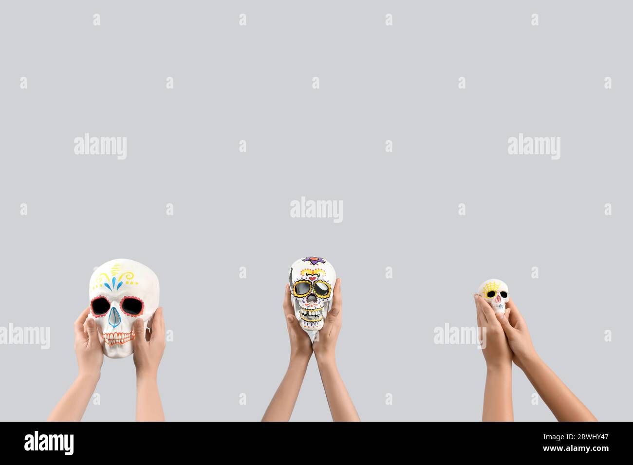 Female hands holding painted human skulls for Mexico's Day of the Dead ...