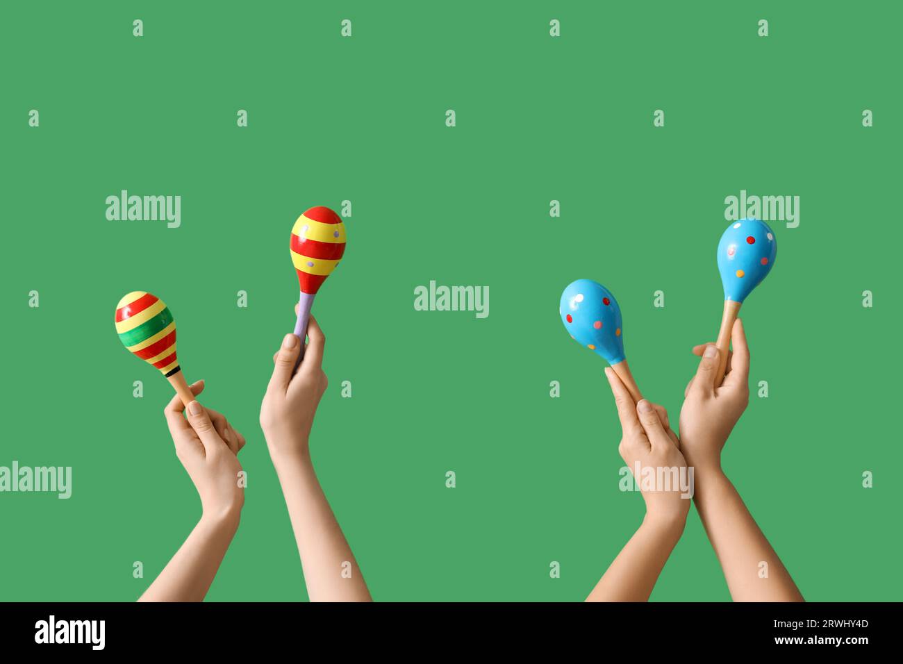 Female hands holding maracas on green background Stock Photo - Alamy