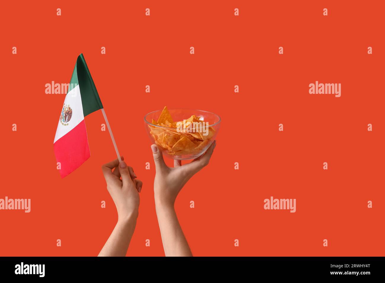 Female hands holding mexican flag and nachos on orange background Stock ...